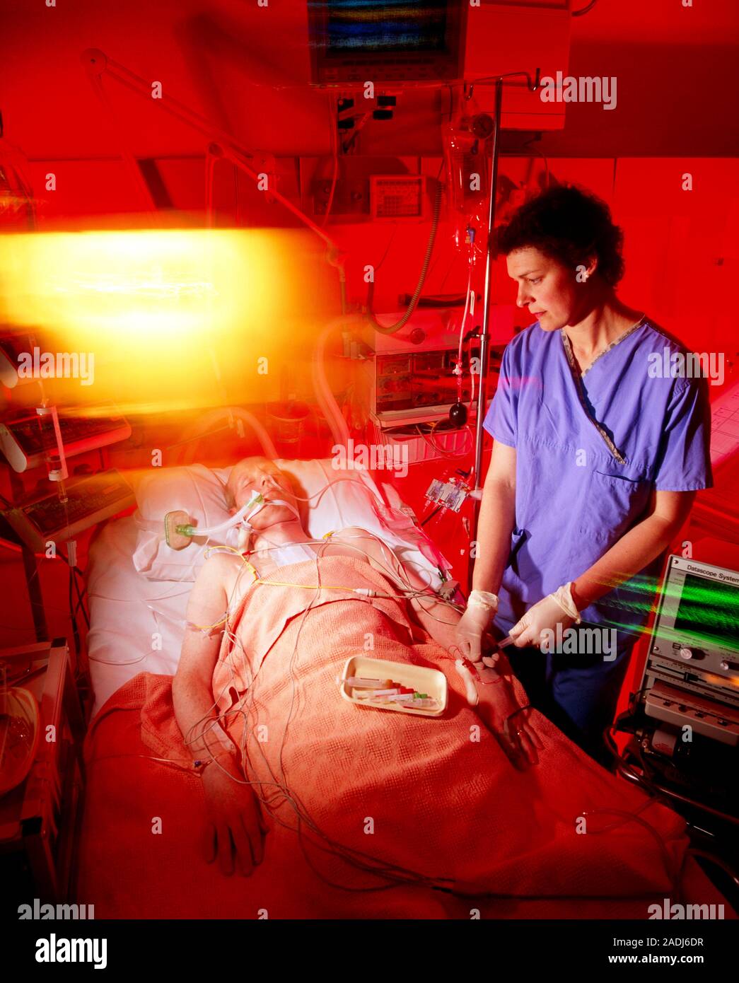 Intensive care. A nurse takes a blood sample from a man in the ...