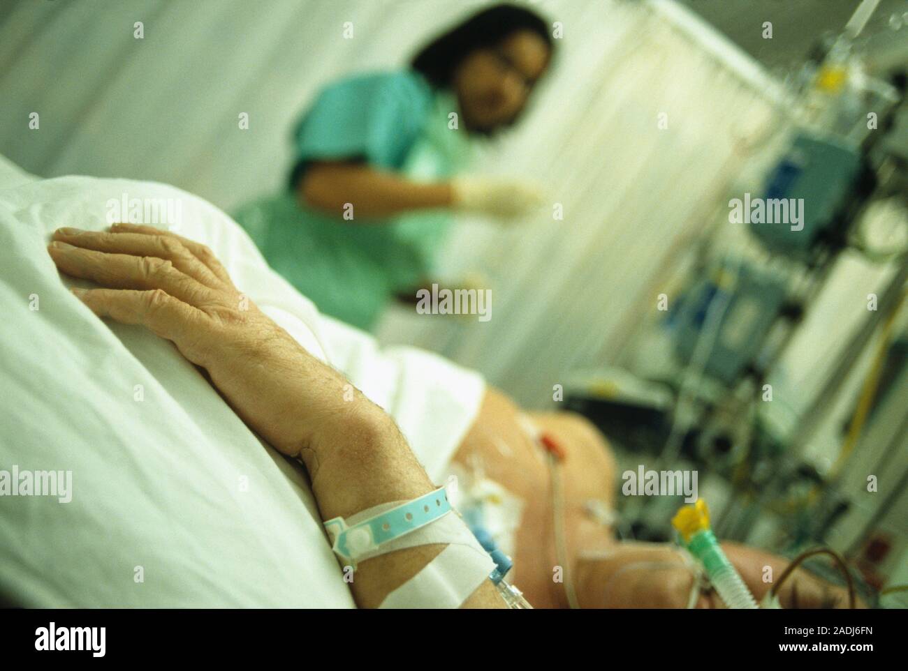Intensive care. Hand of a patient who is being attended by a nurse in ...