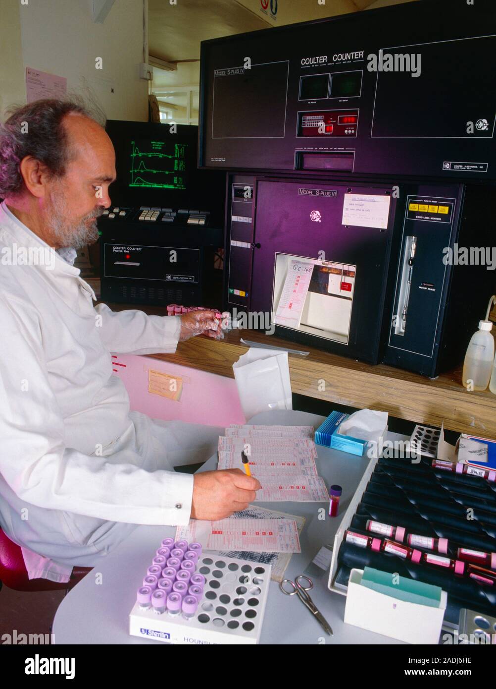 Scientist in a hospital pathology laboratory operating a Coulter ...