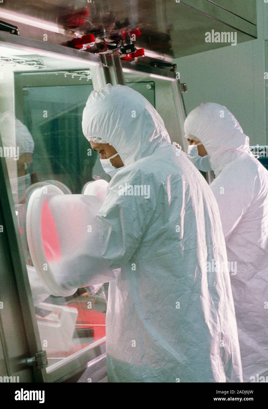 Artificial blood research. Masked technicians work to extract ...