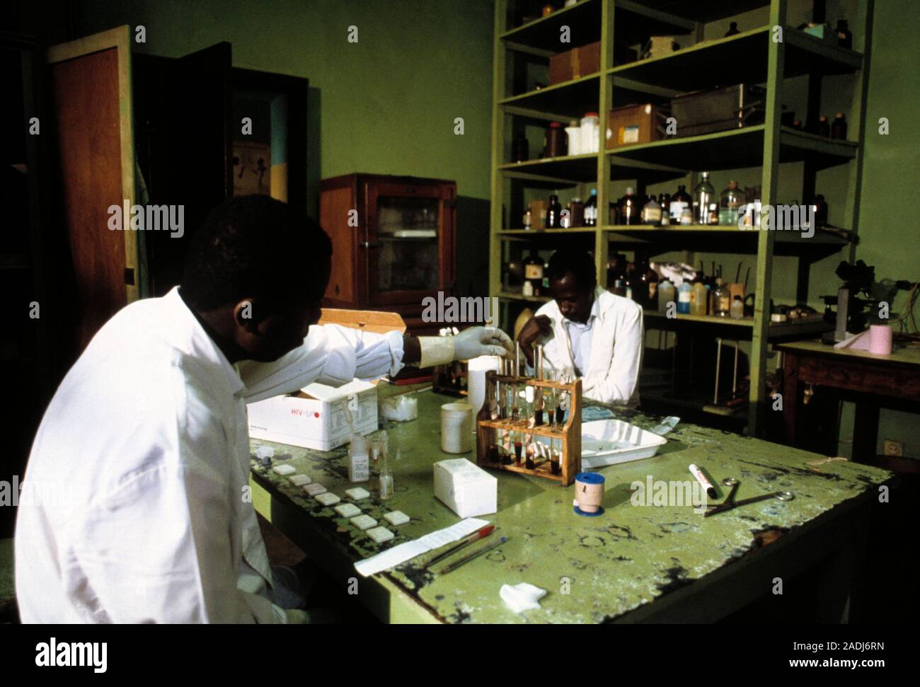AIDS test. Laboratory scientists performing AIDS tests on blood samples ...