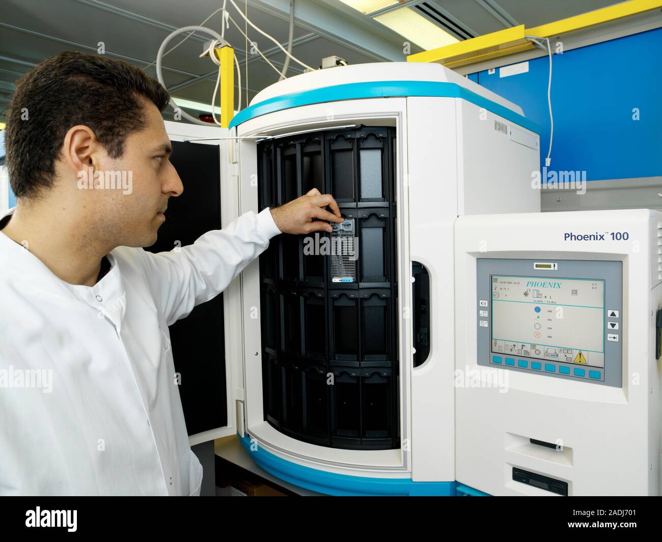 Automated blood bacteria tests. Blood sample container being put in an ...