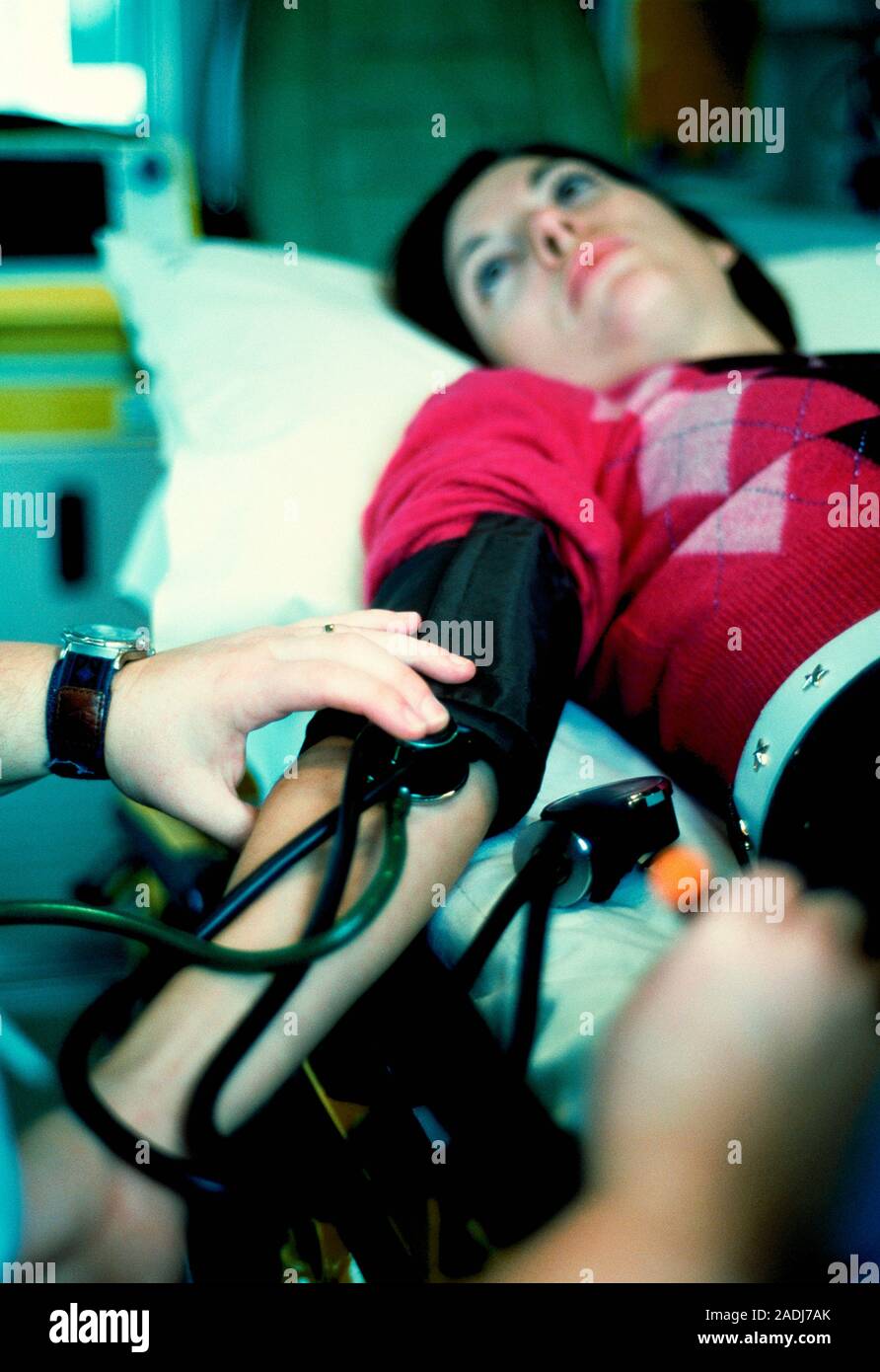 Blood pressure measurement of a female patient. The black cuff (centre ...