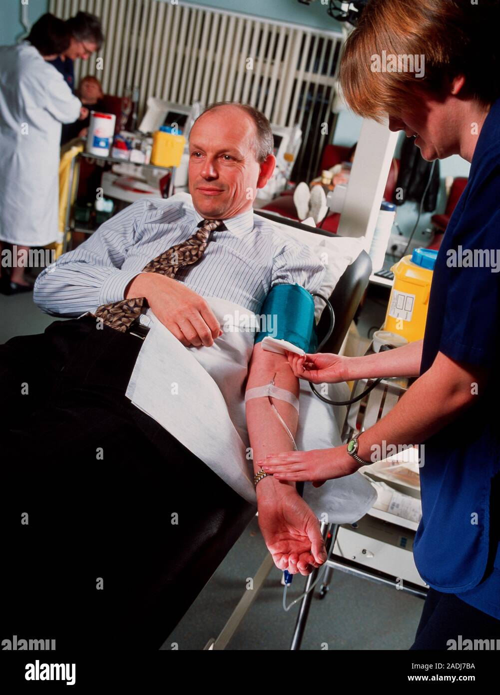 Blood donation. Man donating blood as a member of medical staff ...