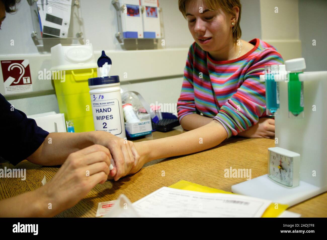 Blood sampling. Potential blood donor having a drop of blood collected ...