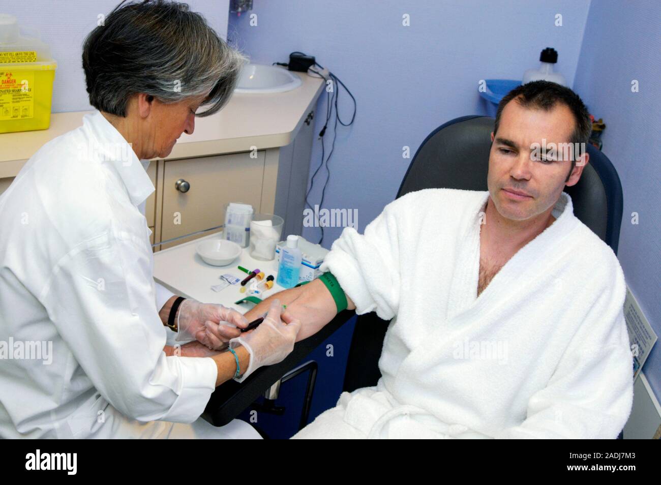 Taking blood sample. Nurse using a needle to puncture a vein ...