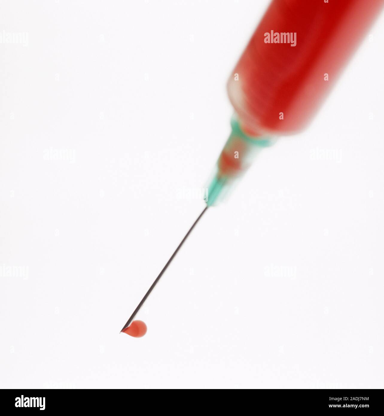 Blood sample. Blood-filled syringe and needle with a drop of blood. The ...