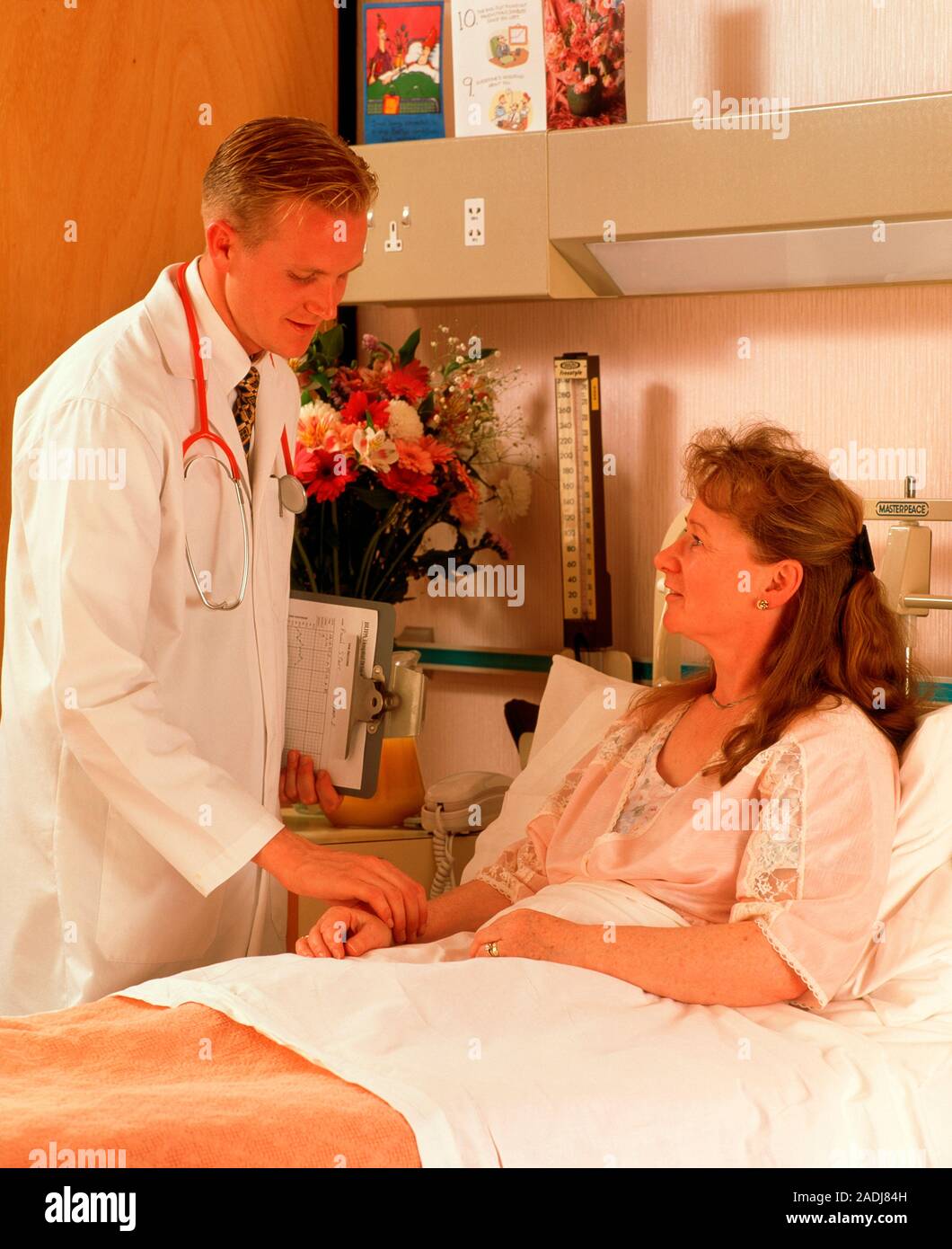 Pulse measurement. Doctor takes the pulse of a woman in a hospital bed ...
