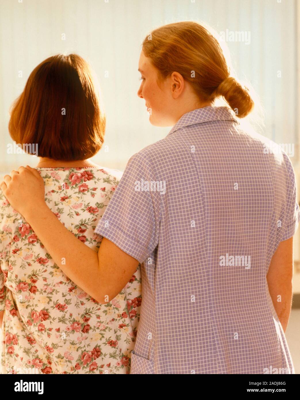 Nurse and patient. View of a hospital nurse comforting a female patient ...