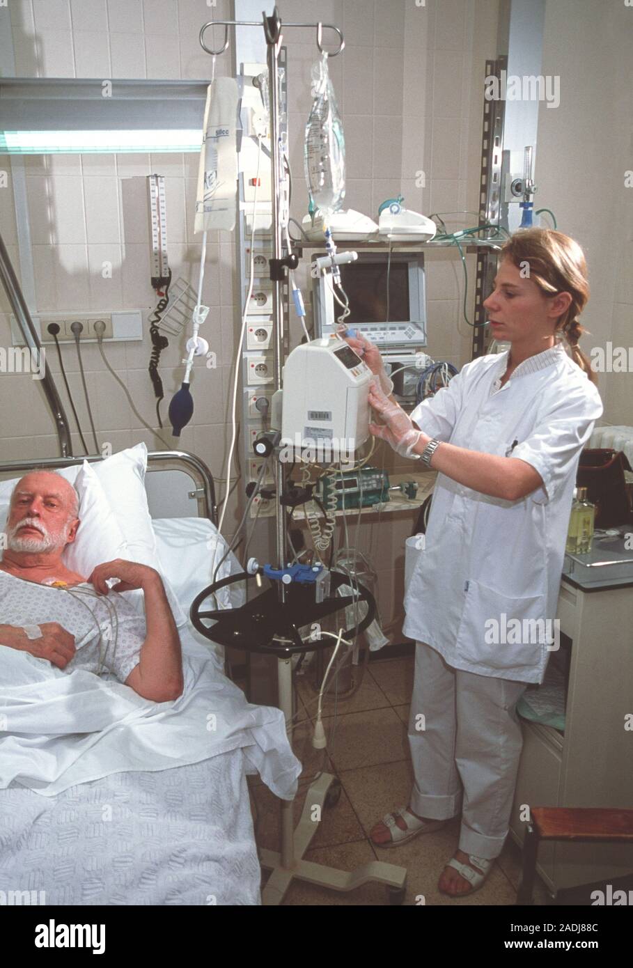 Infusion drip. Nurse adjusting an infusion pump, a type of automated ...