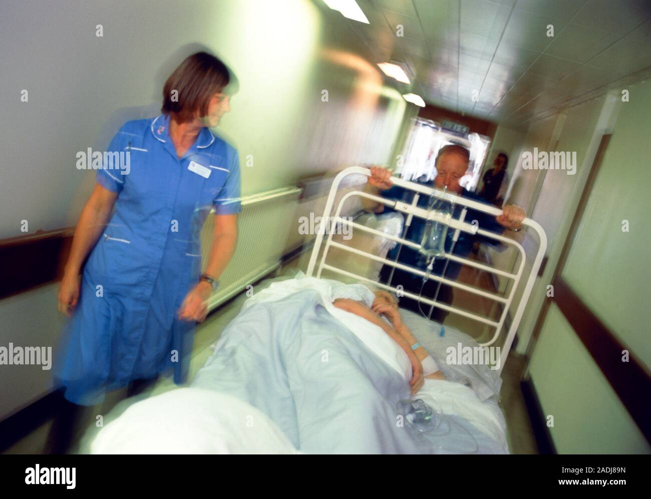 Patient transport. Time-exposure image of a nurse with a bed-bound ...