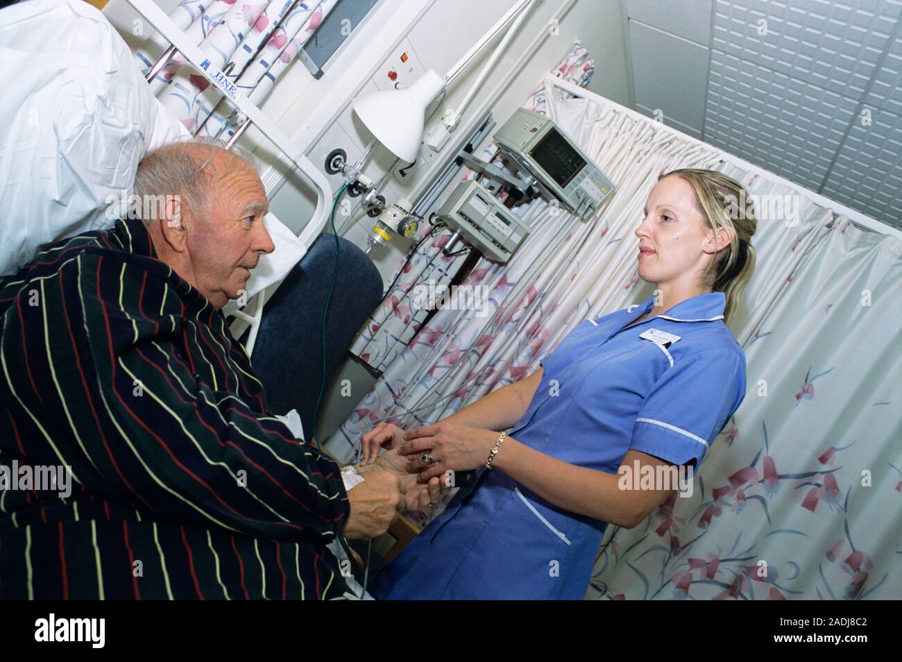 MODEL RELEASED. Checking pulse. Nurse taking a patient's pulse. She is ...