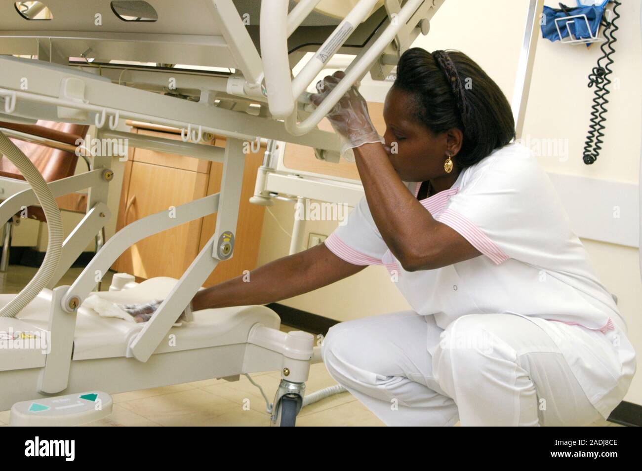Cleaning hospital bed. Hospital cleaner using a cloth to clean and ...