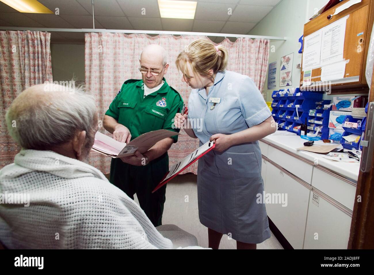 MODEL RELEASED. Patient hand-over. Ambulance technician handing over a ...