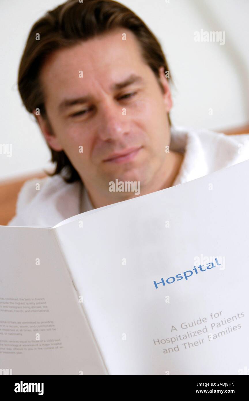 MODEL RELEASED. Hospital patient reading a patient guide Stock Photo ...