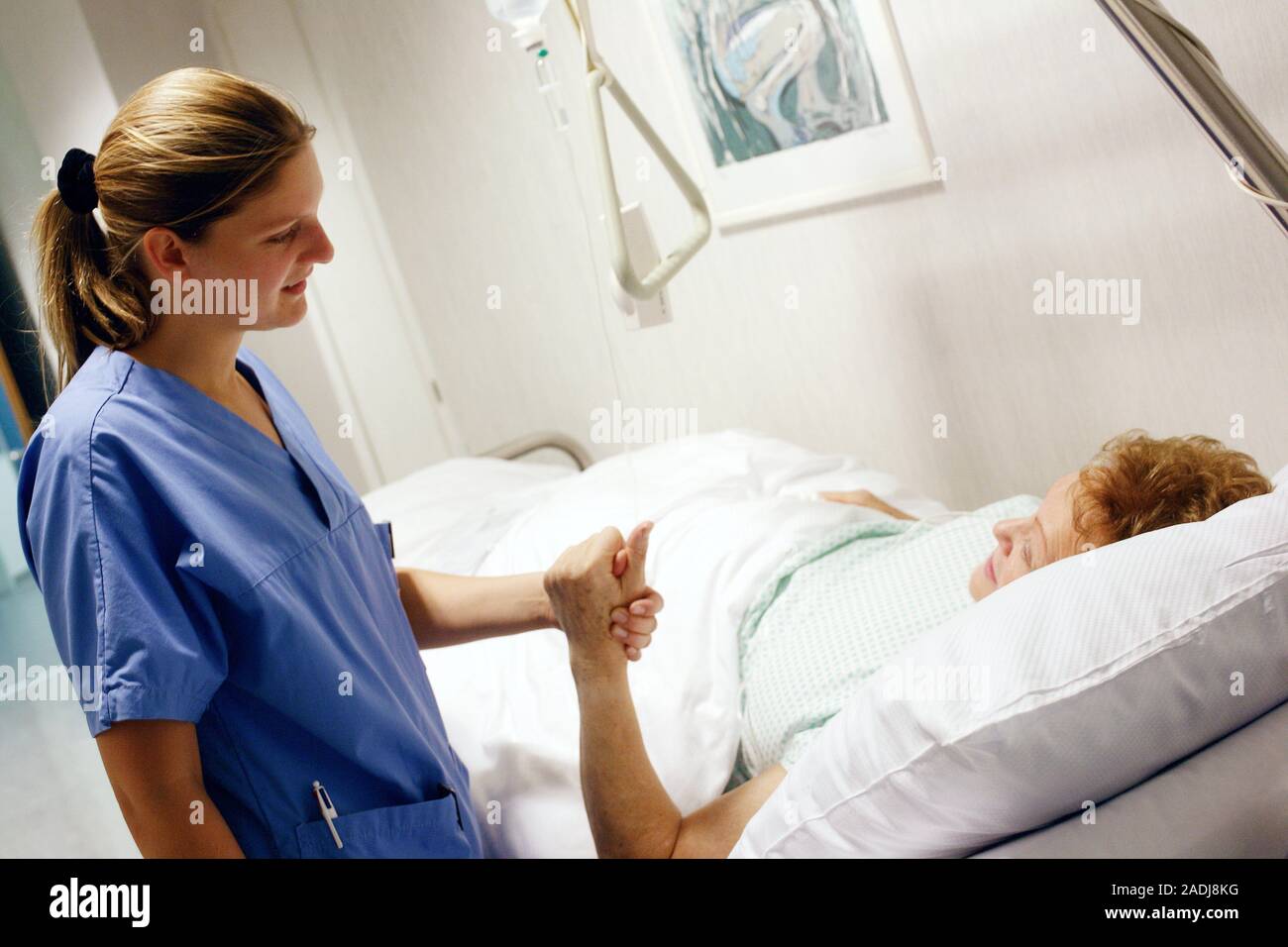 Patient care. Nurse reassuring a patient who is being moved to a ...