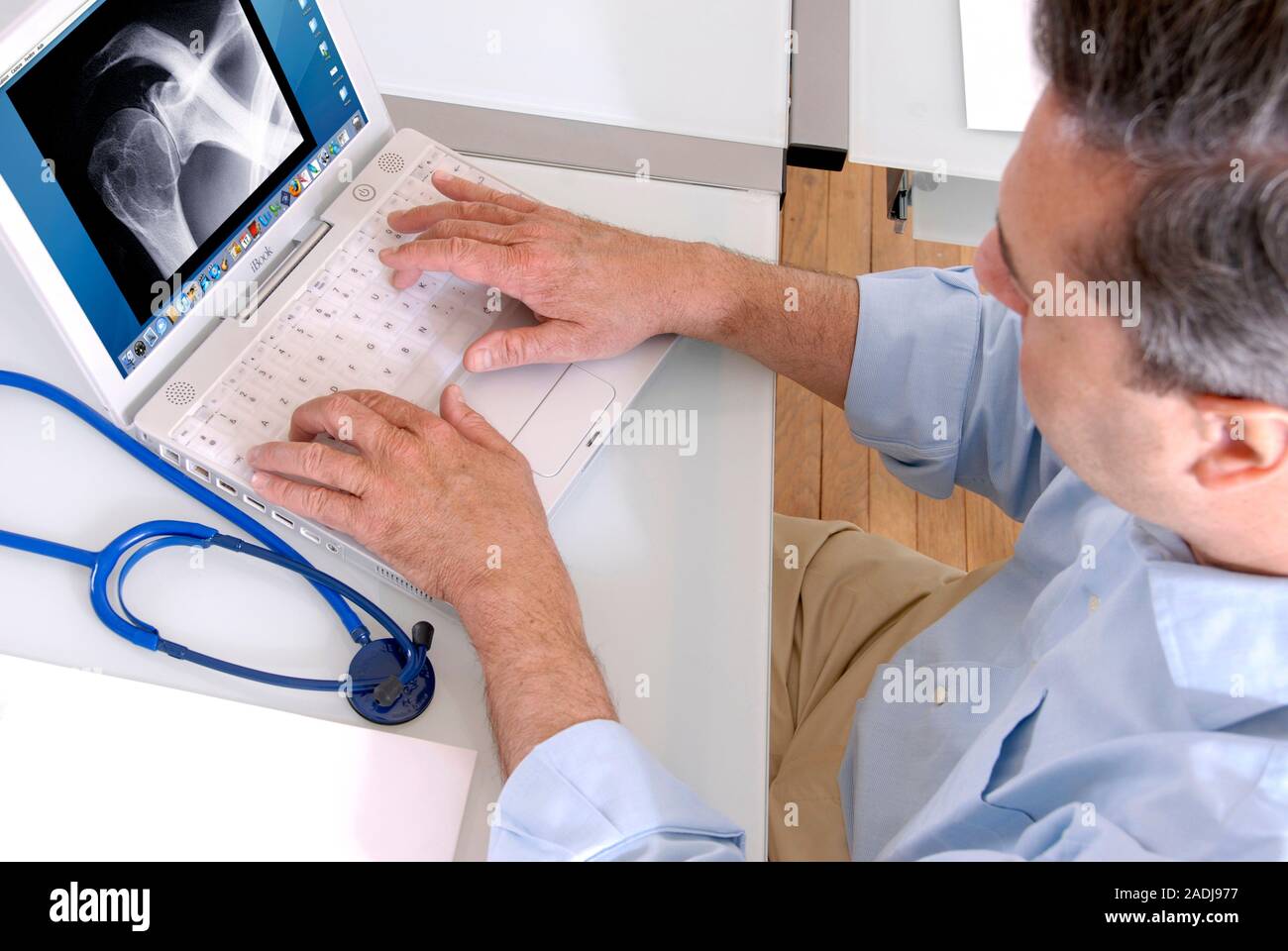MODEL RELEASED. Doctor typing at a laptop computer. The screen displays ...
