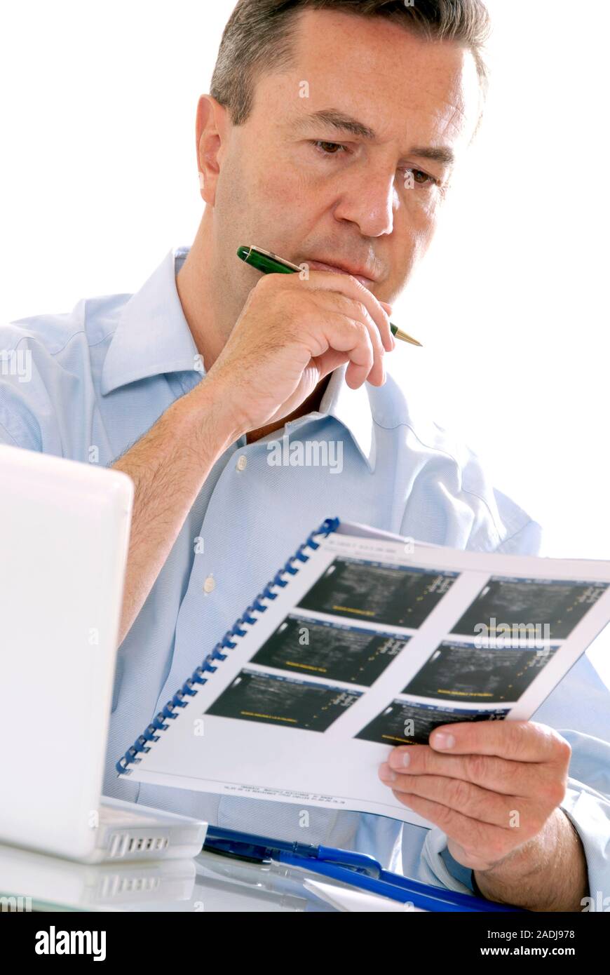 MODEL RELEASED. Doctor reading a document Stock Photo - Alamy