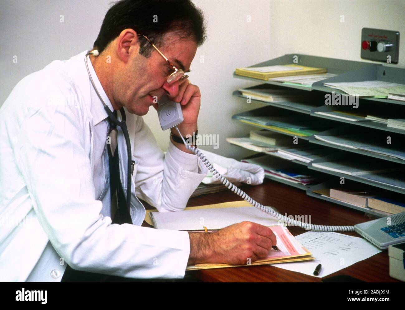 Medical record discussion. General practice doctor on a telephone ...