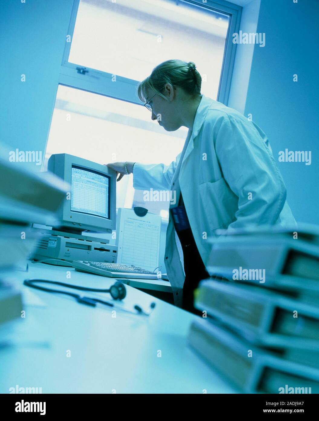 Computerised medical records. Doctor examining medical records on a ...