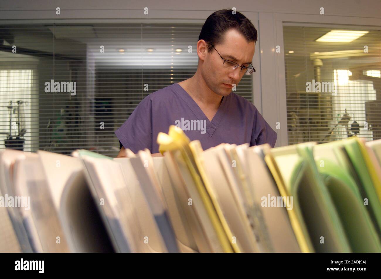 Medical records. Nurse looking through files of medical records ...