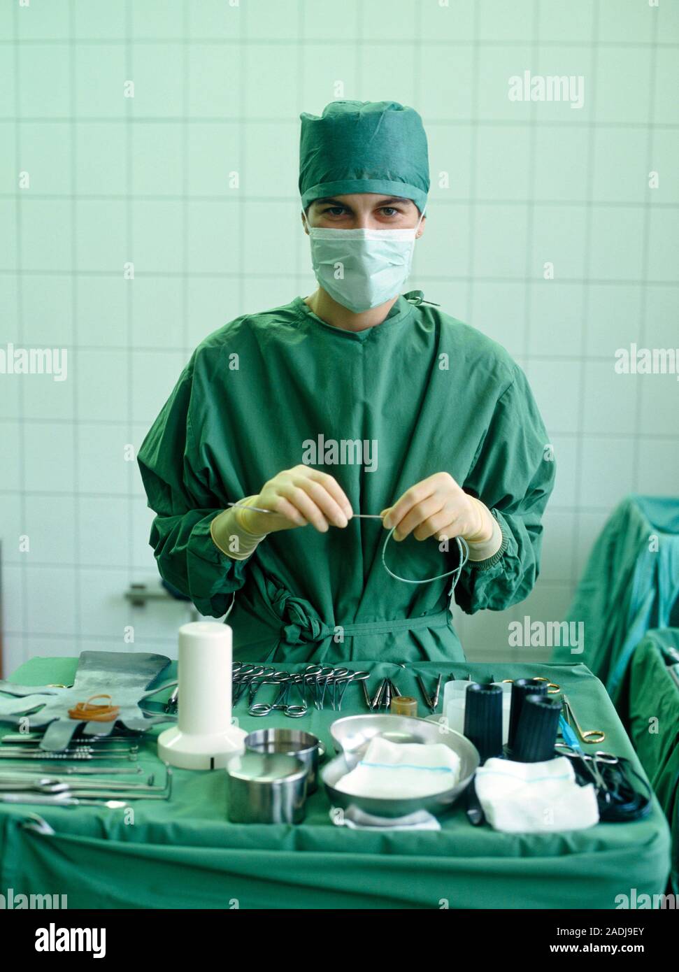 Surgeon or operating theatre assistant with a tray of surgical tools ...