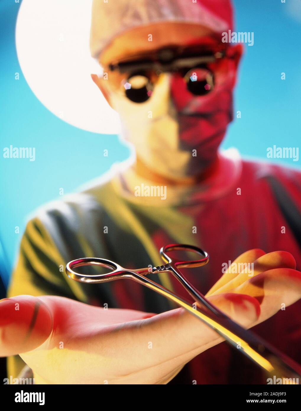 Microsurgery. Surgeon with magnifying lenses over his glasses uses a ...