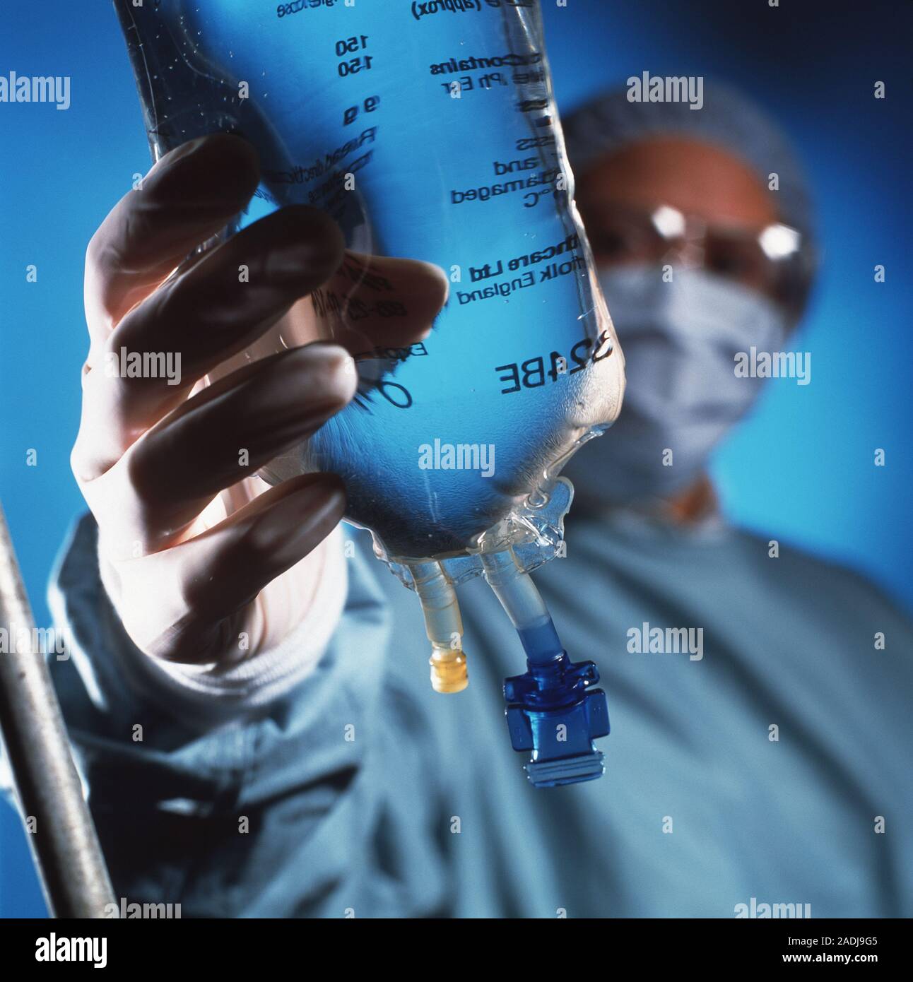 Surgeon and drip bag. View of a surgeon holding an intravenous (IV ...