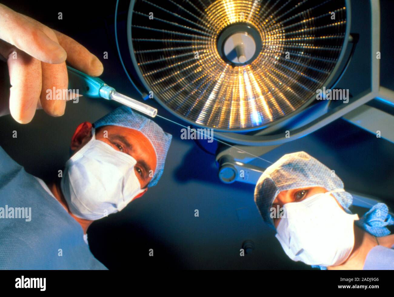 Waterjet dissector. Gloved hand of a surgeon holds a waterjet dissector ...