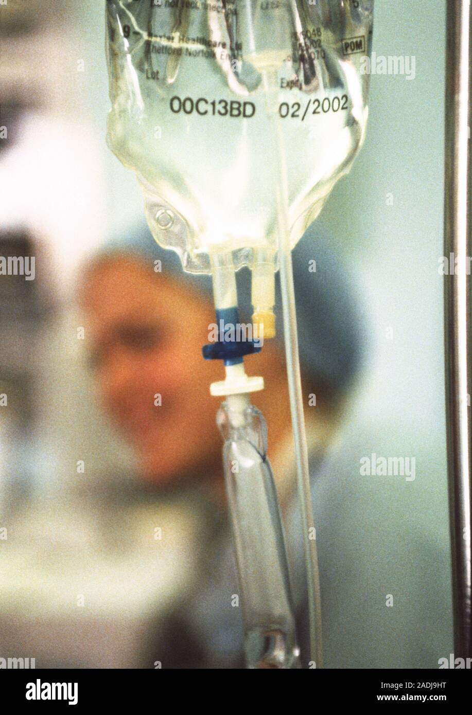 Intravenous drip (foreground) in use during surgery in a hospital ...
