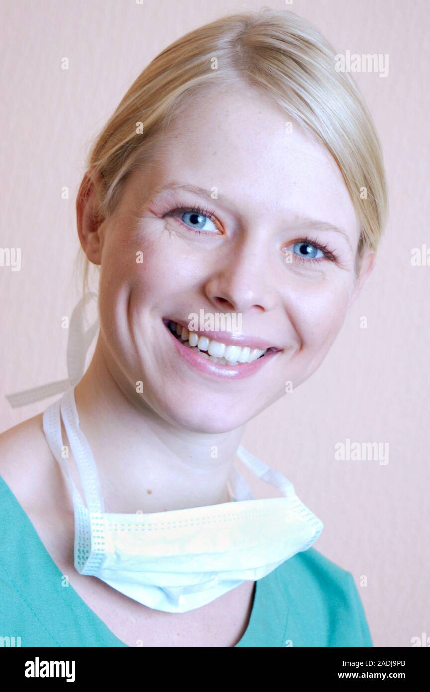 MODEL RELEASED. Doctor smiling with a surgical mask round her neck ...