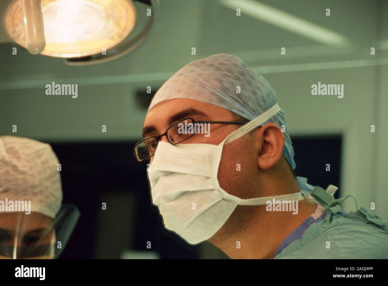 Hospital surgeon wearing a face mask to help prevent infection. He is ...