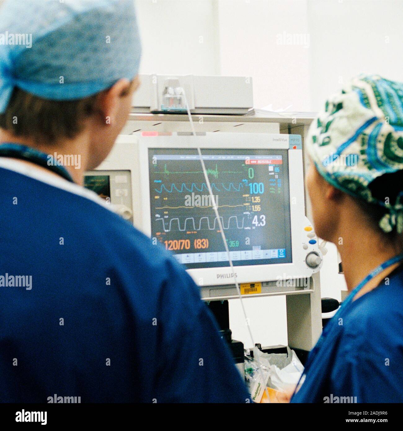 MODEL RELEASED. Surgery monitor. Medical staff using a monitor to ...
