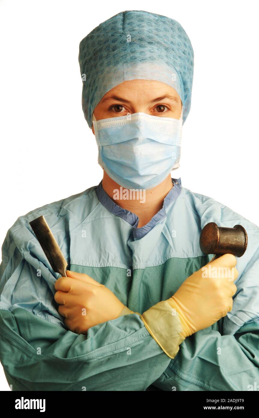 MODEL RELEASED. Female orthopedic surgeon holding a chisel and mallet ...