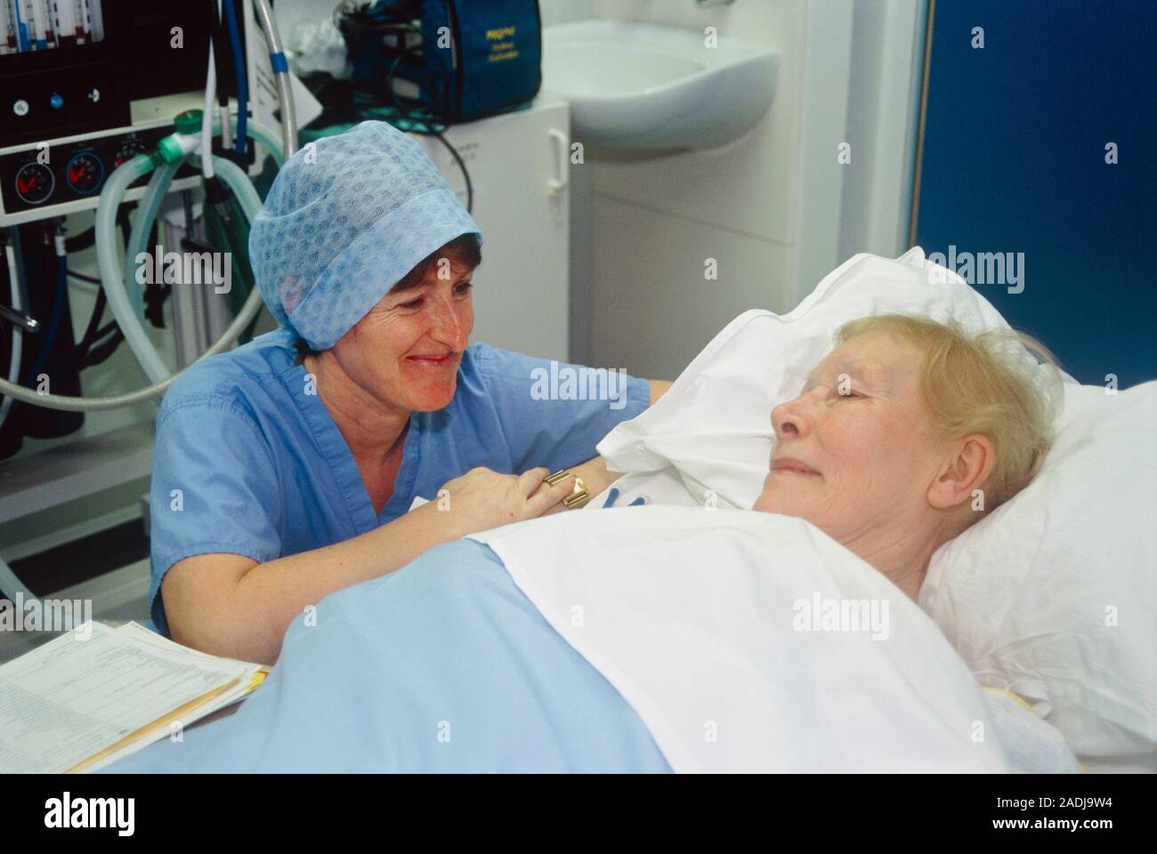 MODEL RELEASED. Theatre nurse comforting a patient in an operating ...