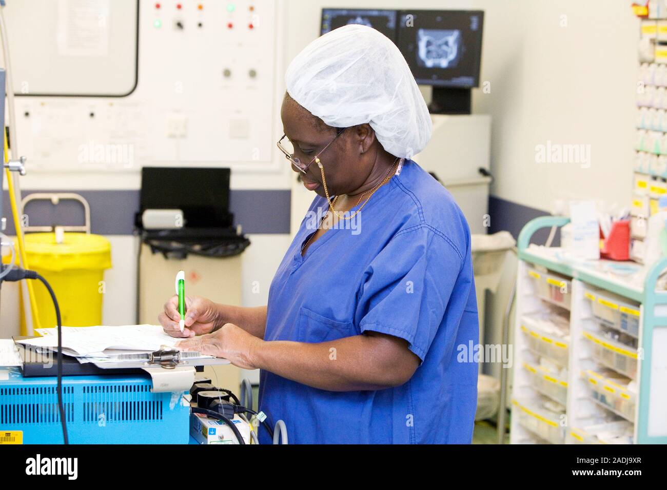 Hospital administration. Nurse making notes during an operation Stock ...