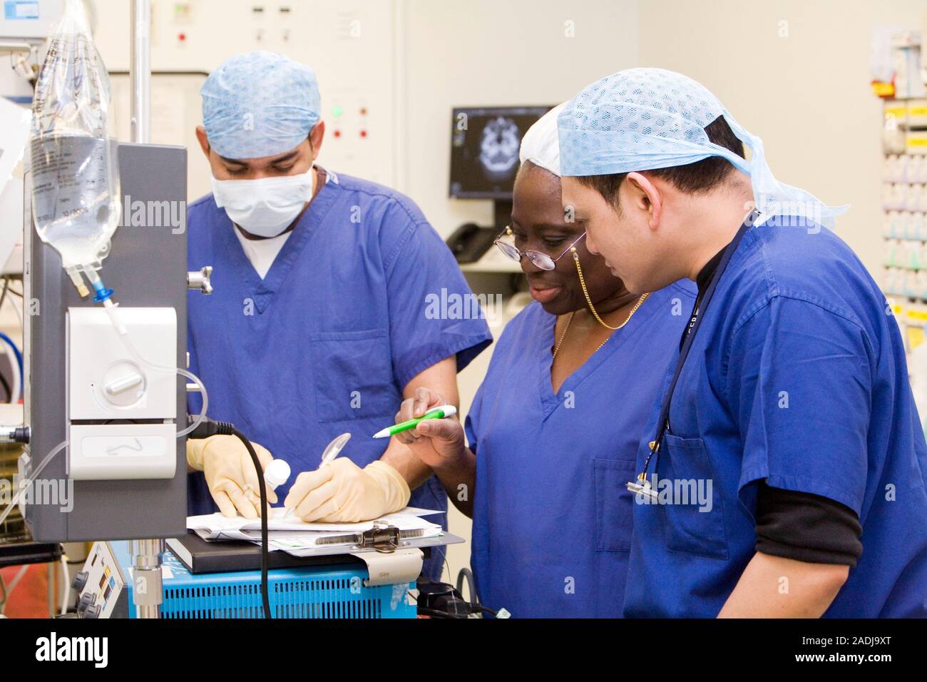 Hospital administration. Nurse and doctors making notes on a patient in ...