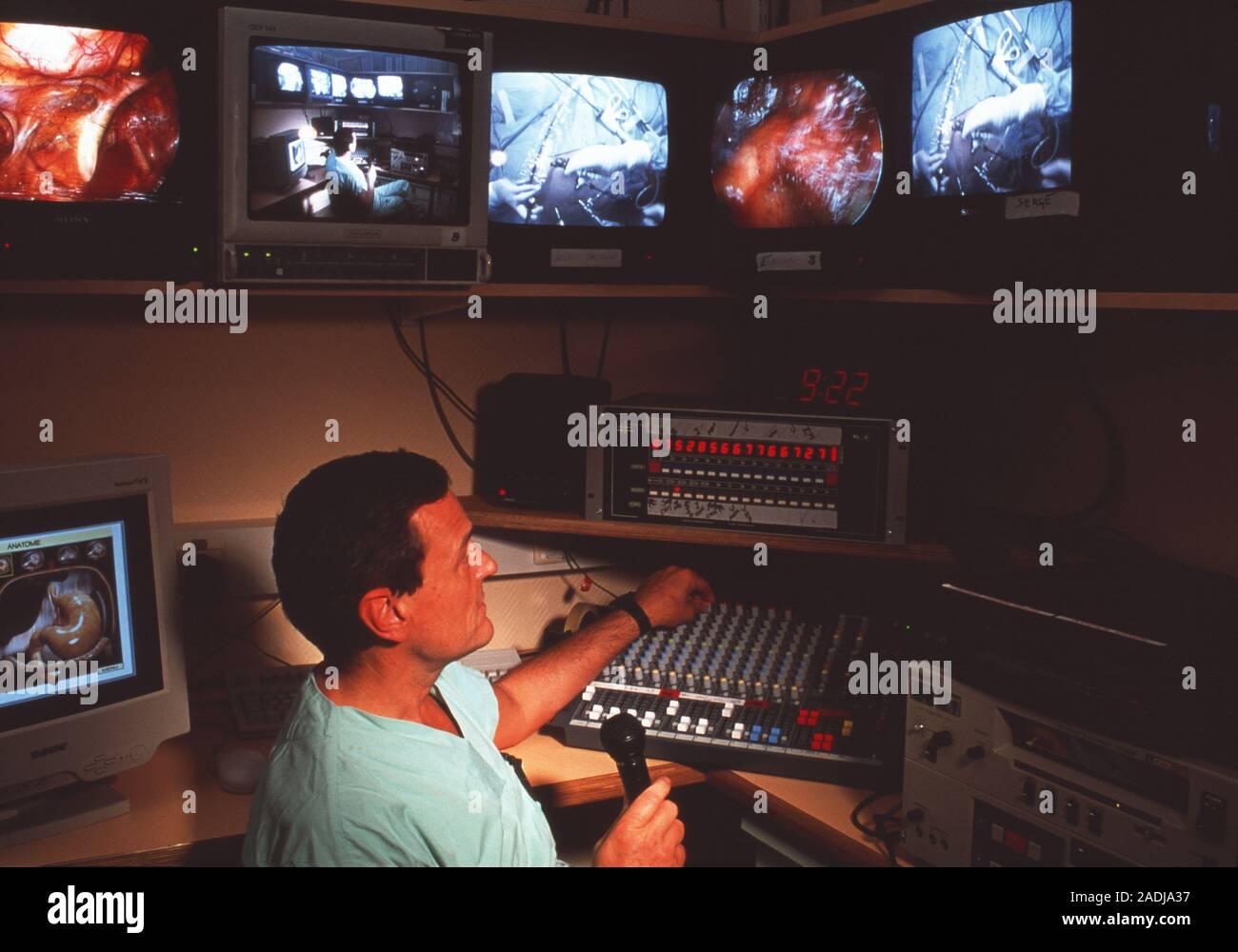 Surgery. Surgeon talking into a microphone as he follows an operation ...