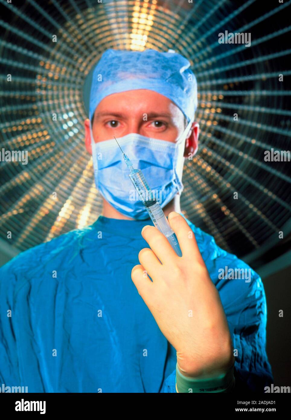 Anaesthetic injection. Male anaesthetist wearing surgical dress, cap ...