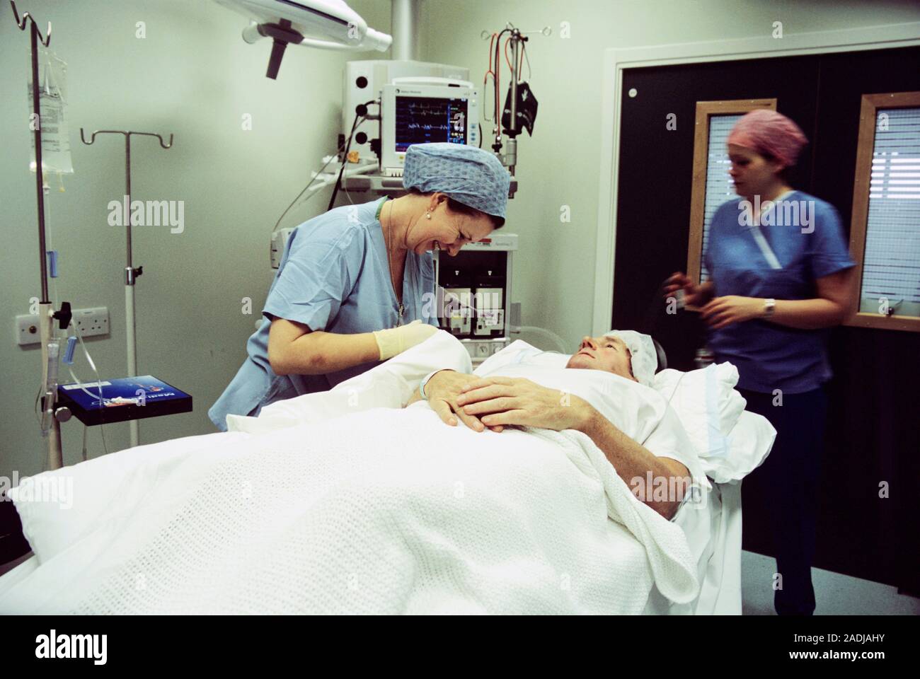 MODEL RELEASED. Surgery preparation. Anaesthetists preparing a patient ...