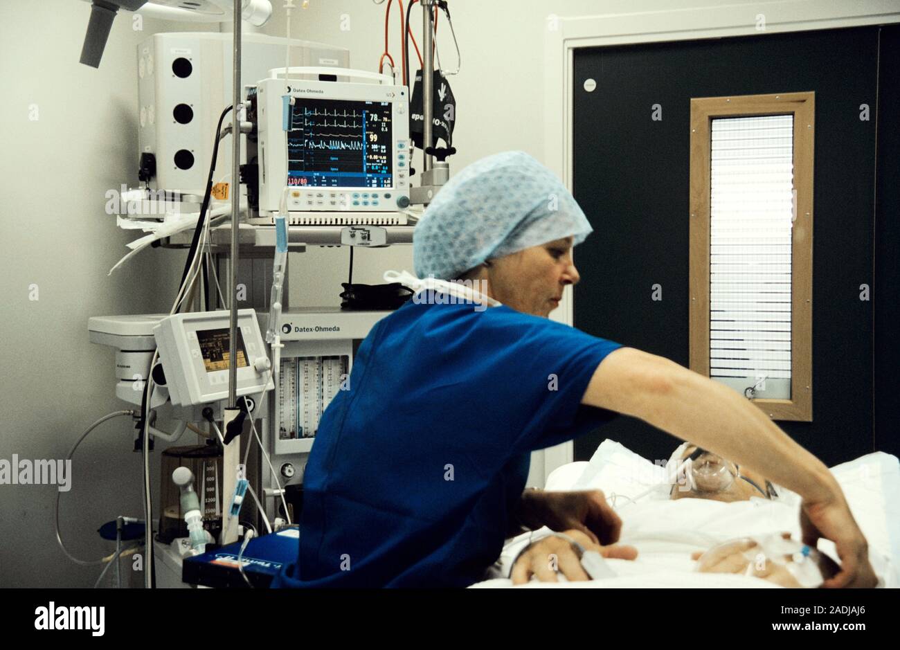 MODEL RELEASED. Surgery preparation. Anaesthetist preparing a patient ...