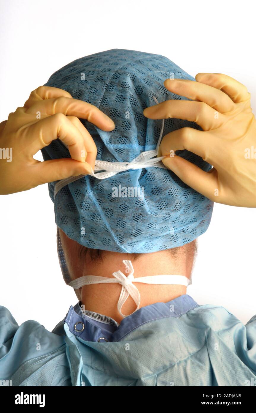 MODEL RELEASED. Female surgeon putting on a hair net Stock Photo - Alamy