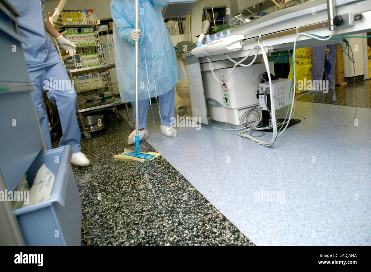 Surgical hygiene. Surgical nurse using a mop to clean the floor of an ...