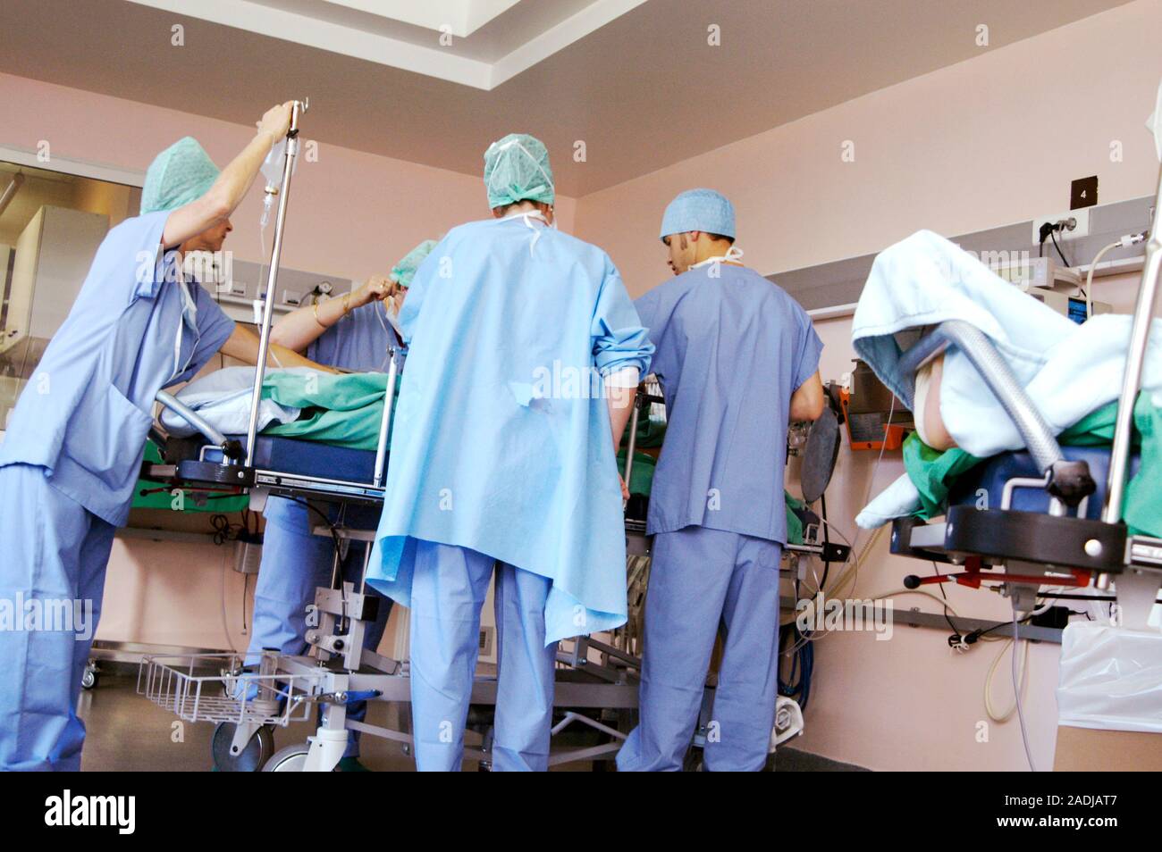 MODEL RELEASED. Post-operative care. Doctor and nurses attending to a ...