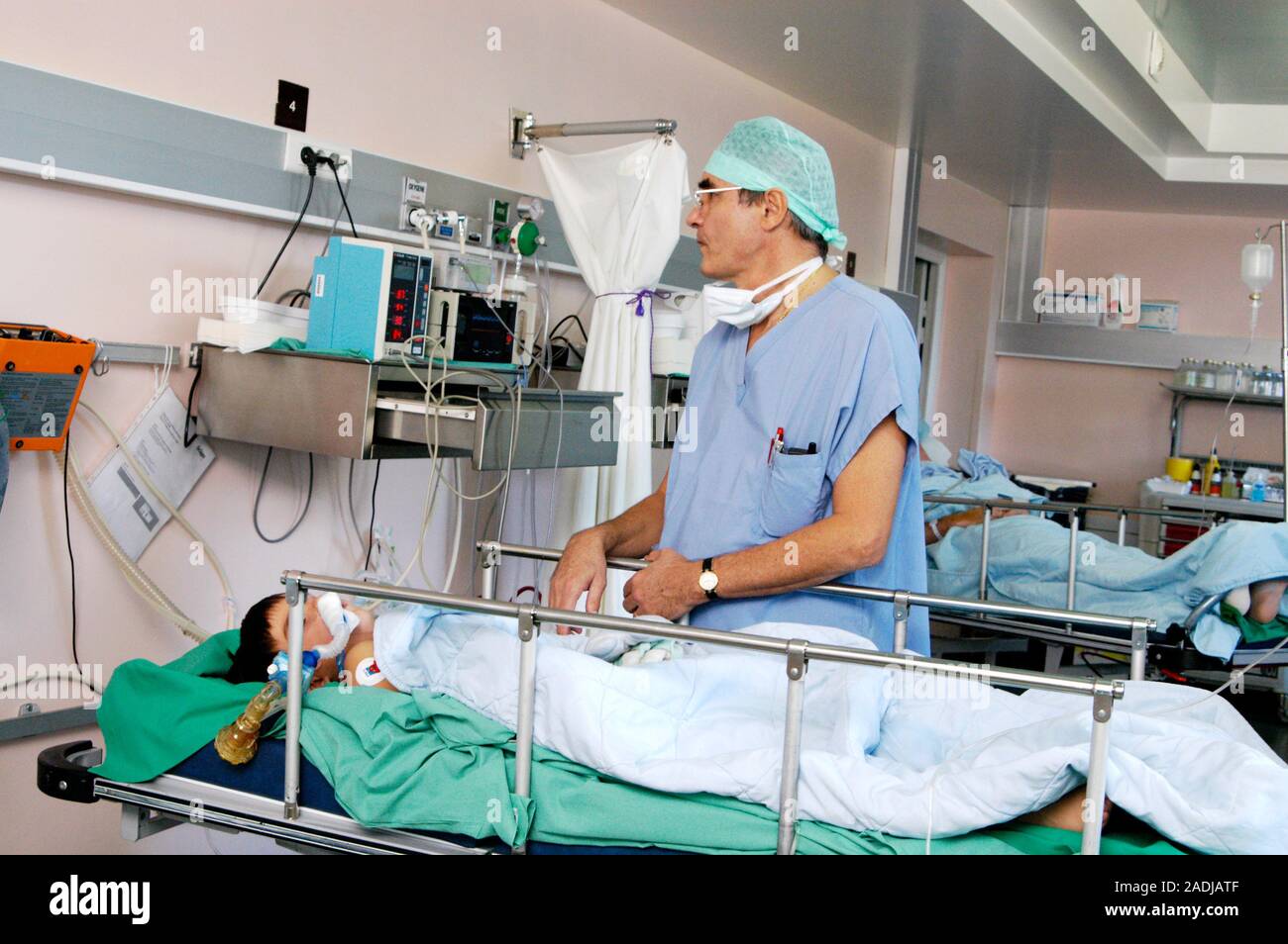 MODEL RELEASED. Post-operative care. Anaesthetist checking a 7-year-old ...