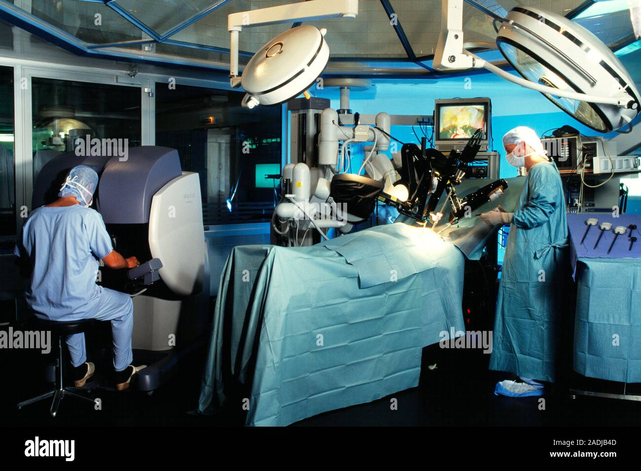 Robot surgery. Surgeon (left, at console) performing minimally invasive ...