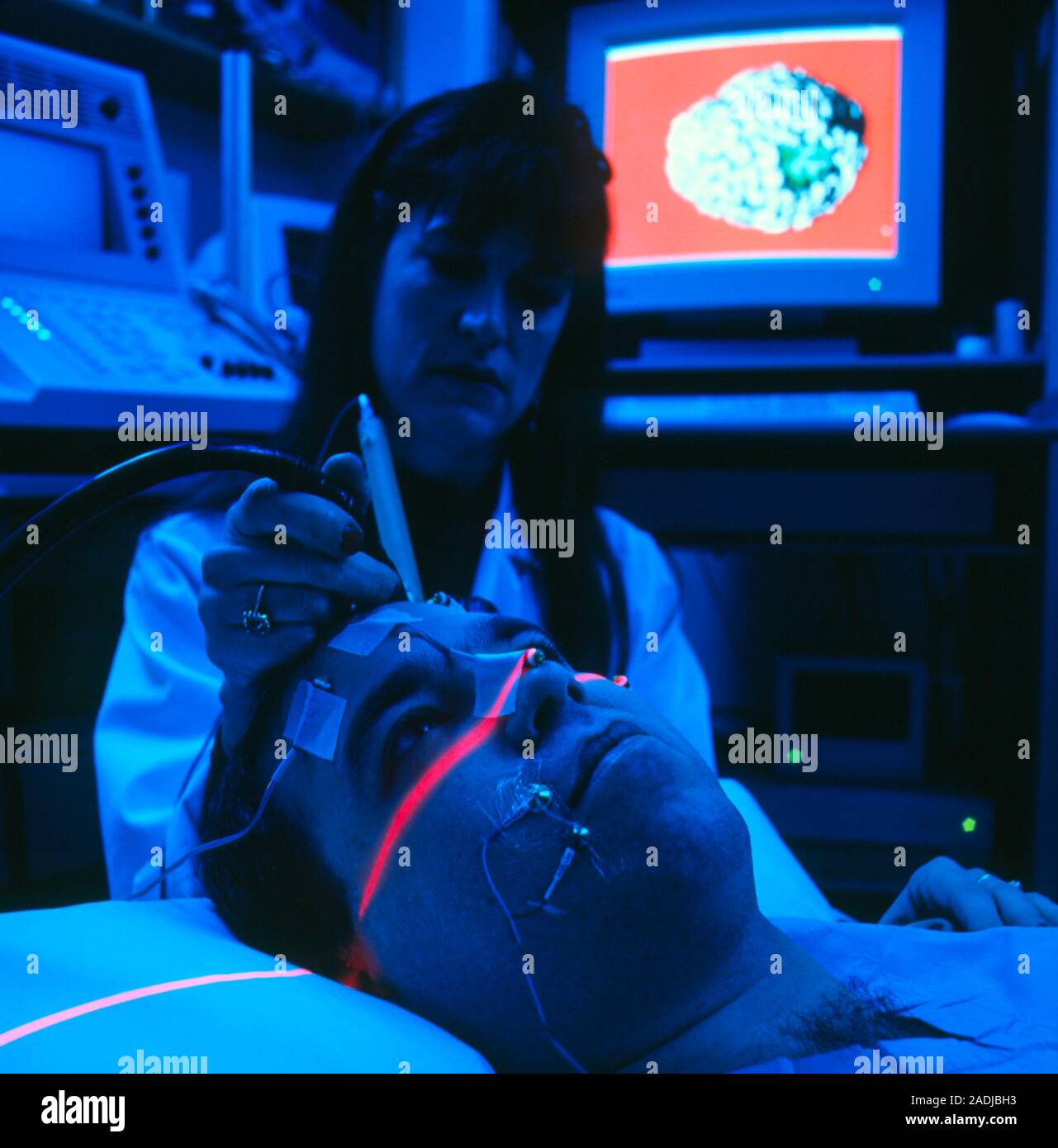 Computer-aided neurosurgery. View of a technician preparing a patient ...