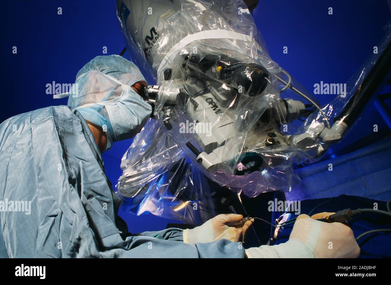 Robot-assisted surgery. Surgeon performing a brain operation using the ...