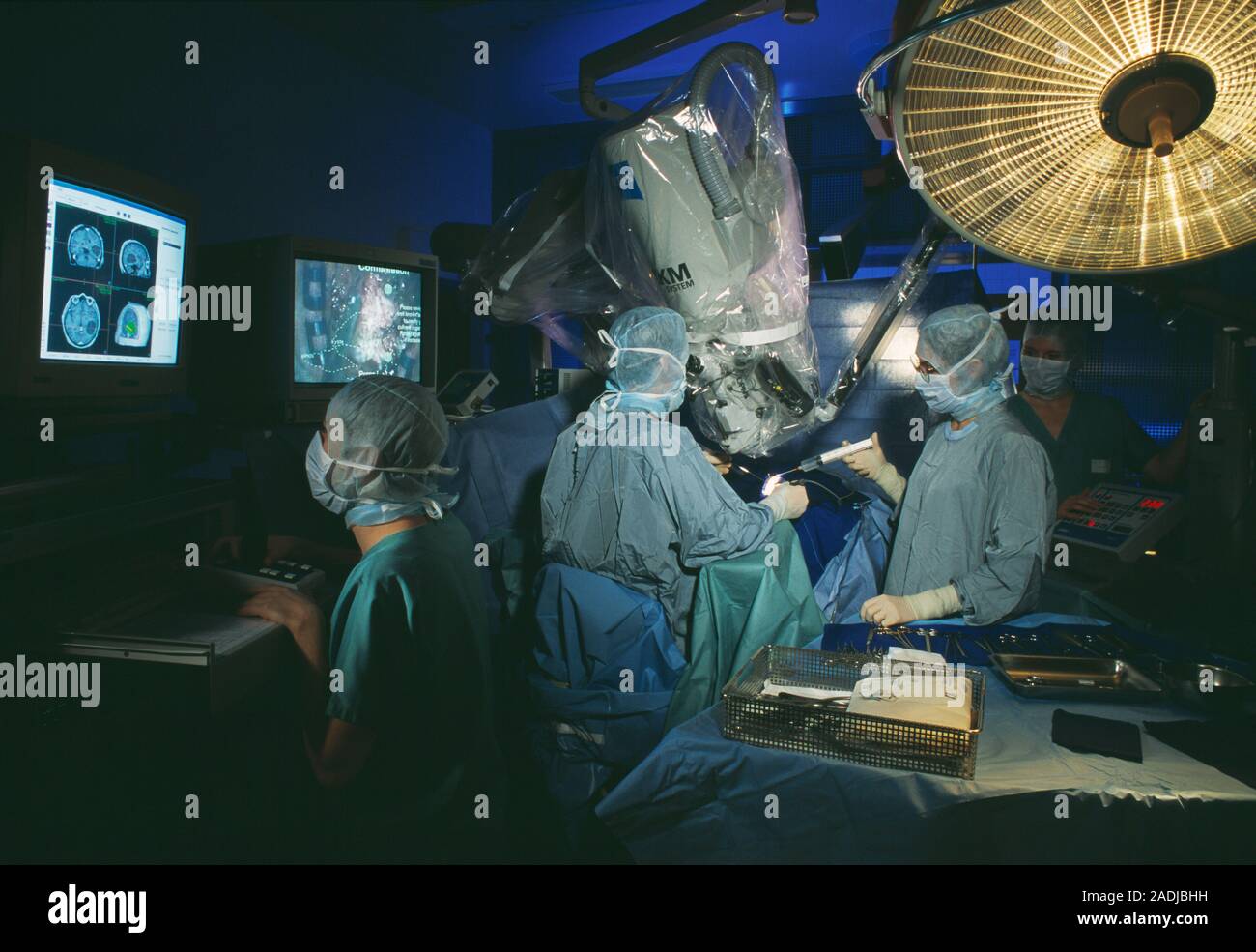 Robot-assisted surgery. Surgeons performing a brain operation using the ...