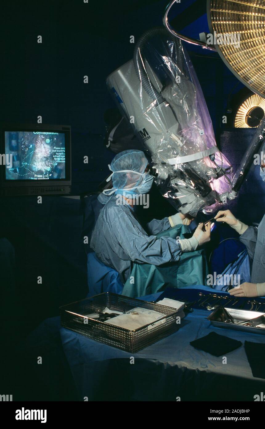 Robot-assisted surgery. Surgeons performing a brain operation using the ...